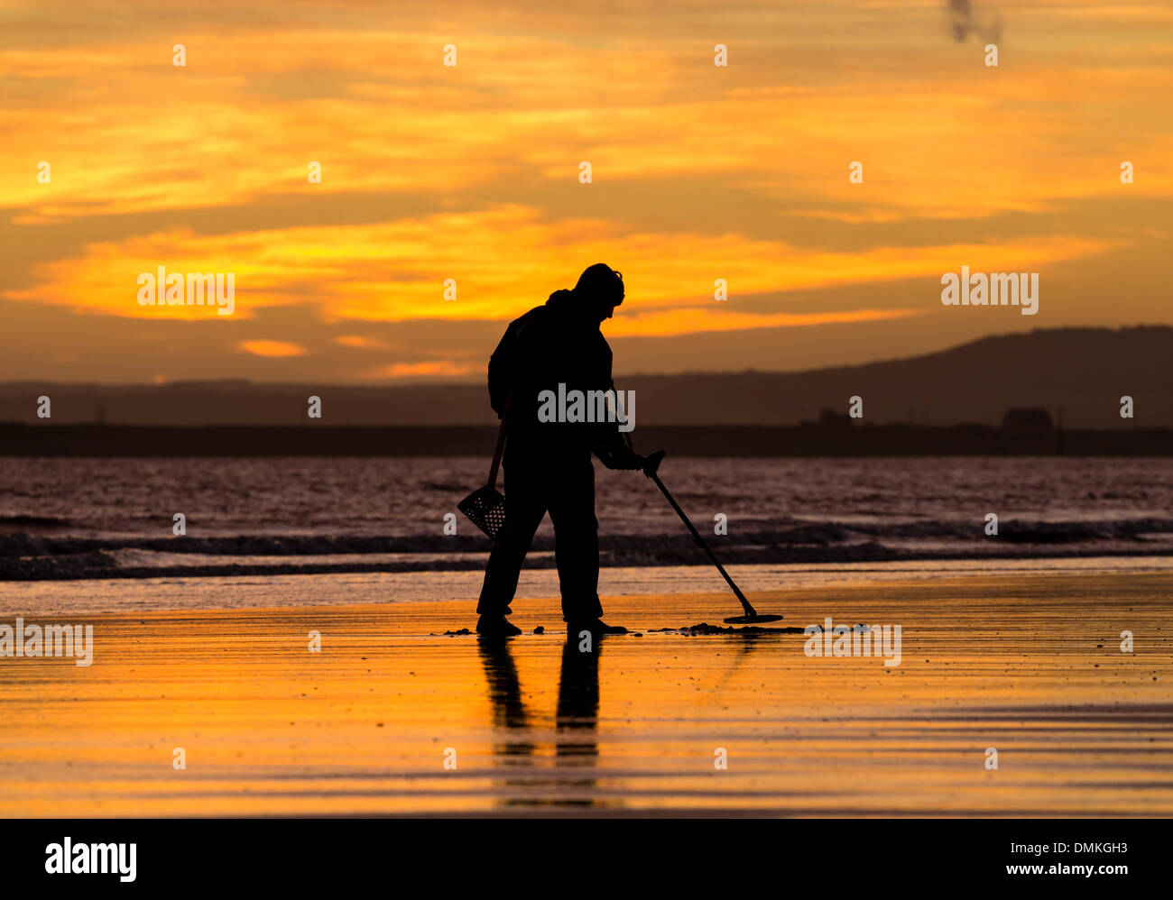Man metal detecting with metal detector on beach. UK Stock Photo - Alamy