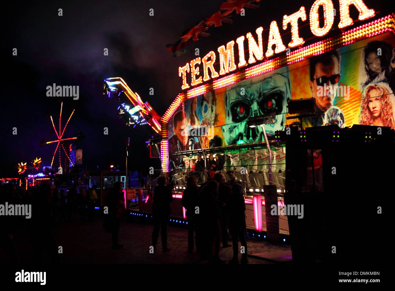 A fairground lit up at night showing Terminator ride Stock Photo - Alamy