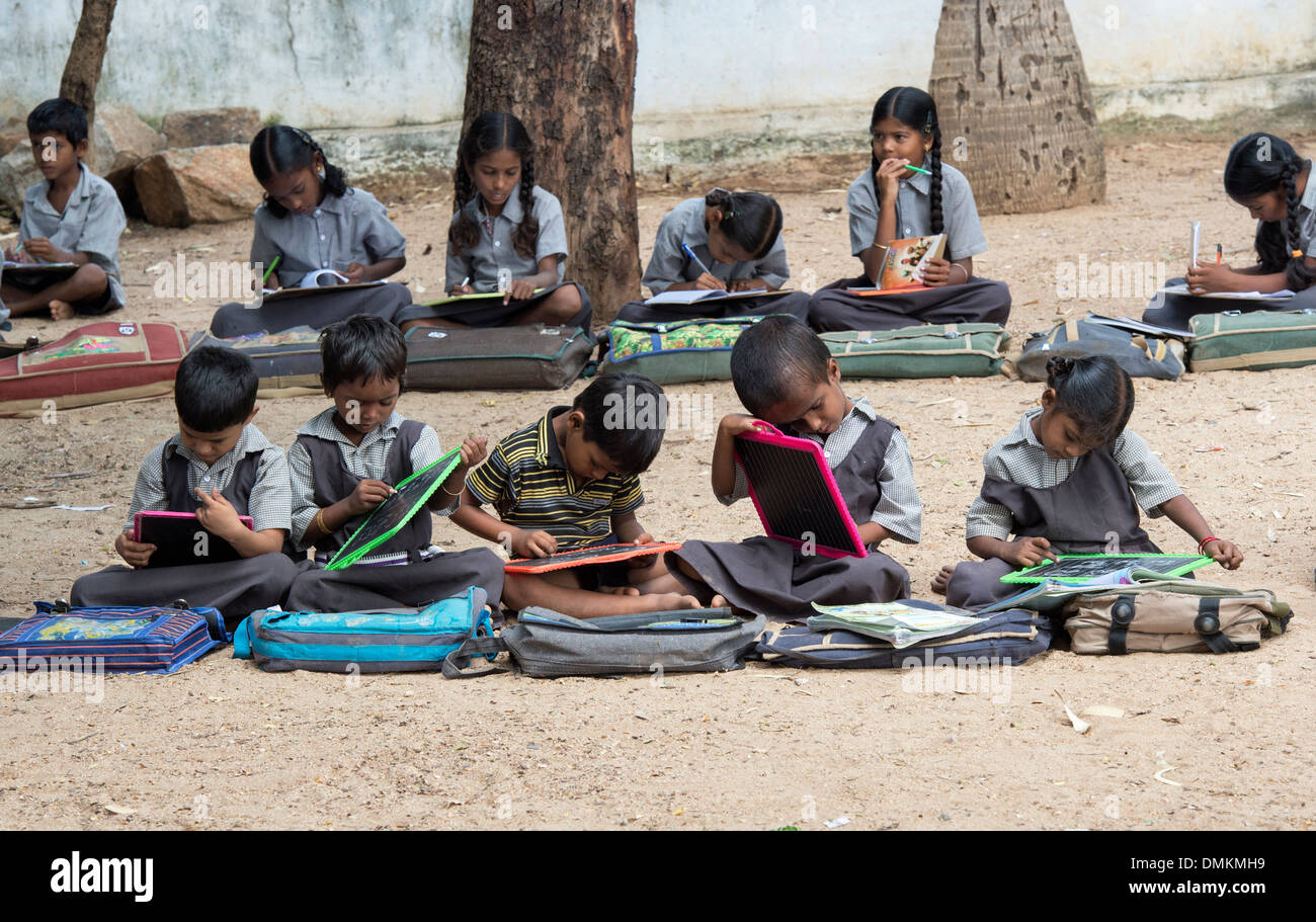 Rural Indian village school children in an outside class writing on a ...