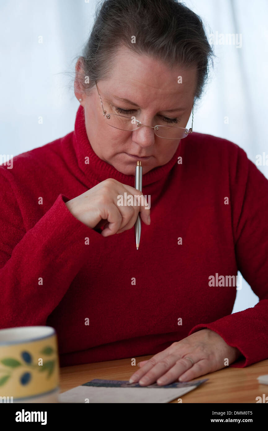 Woman at dining room table writing letters Stock Photo - Alamy