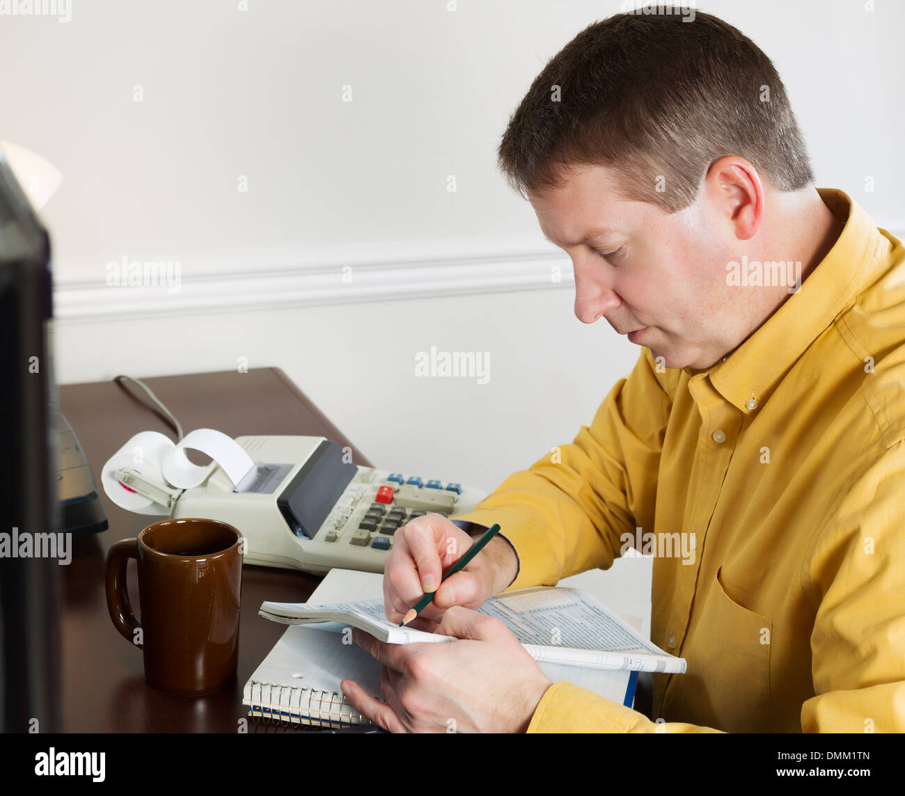 Photo of mature man, recording data from the computer, working on his ...