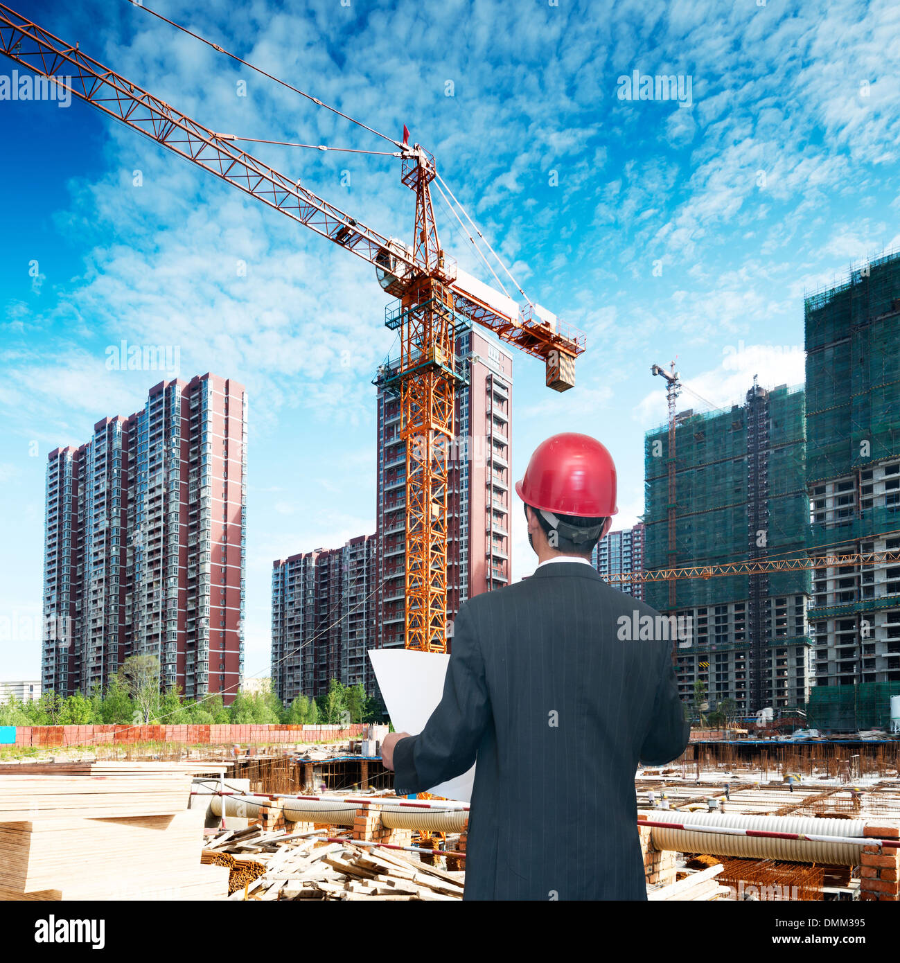 Rear view of architect looking comparing housing project with building ...