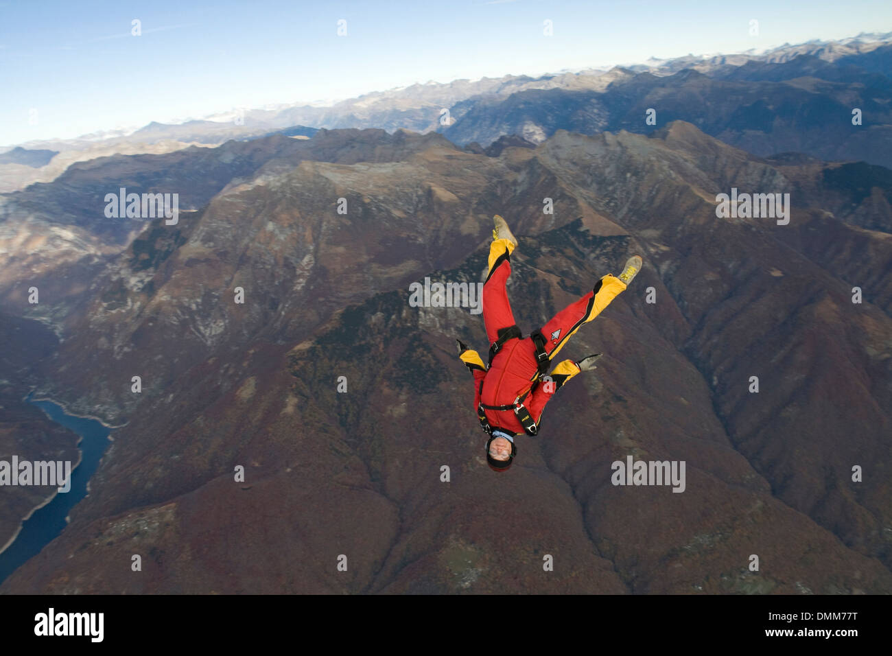 This skydiver woman is falling free in a head down position over a ...