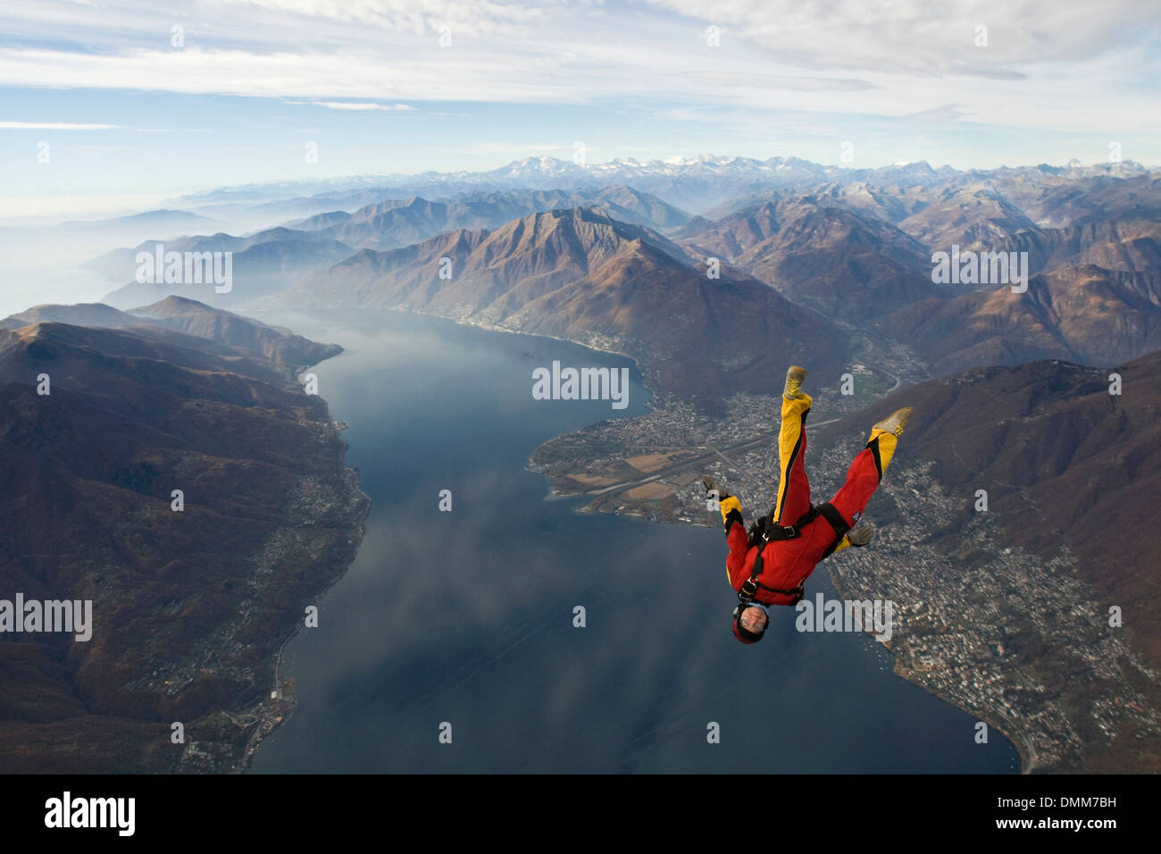 This skydiver woman is falling free in a head down position over a city ...