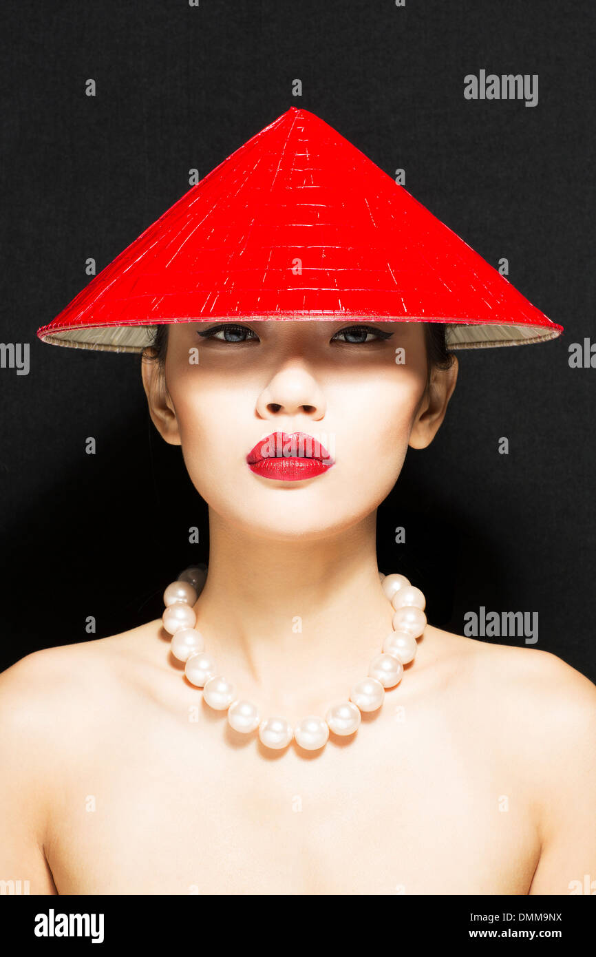 Vietnamese model wearing traditional red conical hat Stock Photo - Alamy