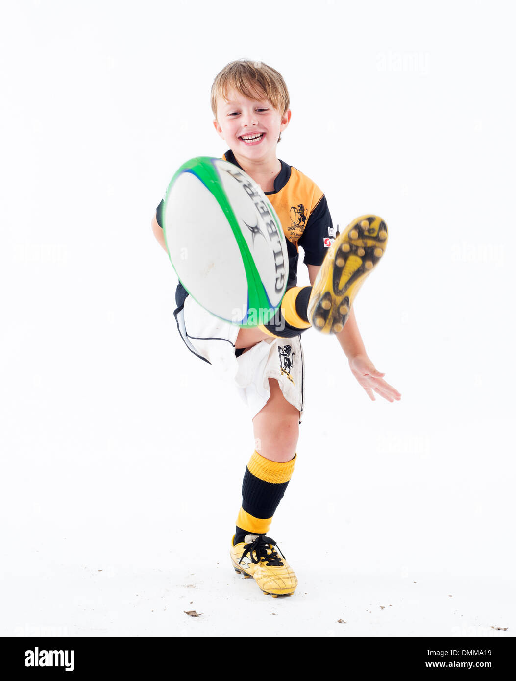 Boy kicking rugby ball Stock Photo - Alamy