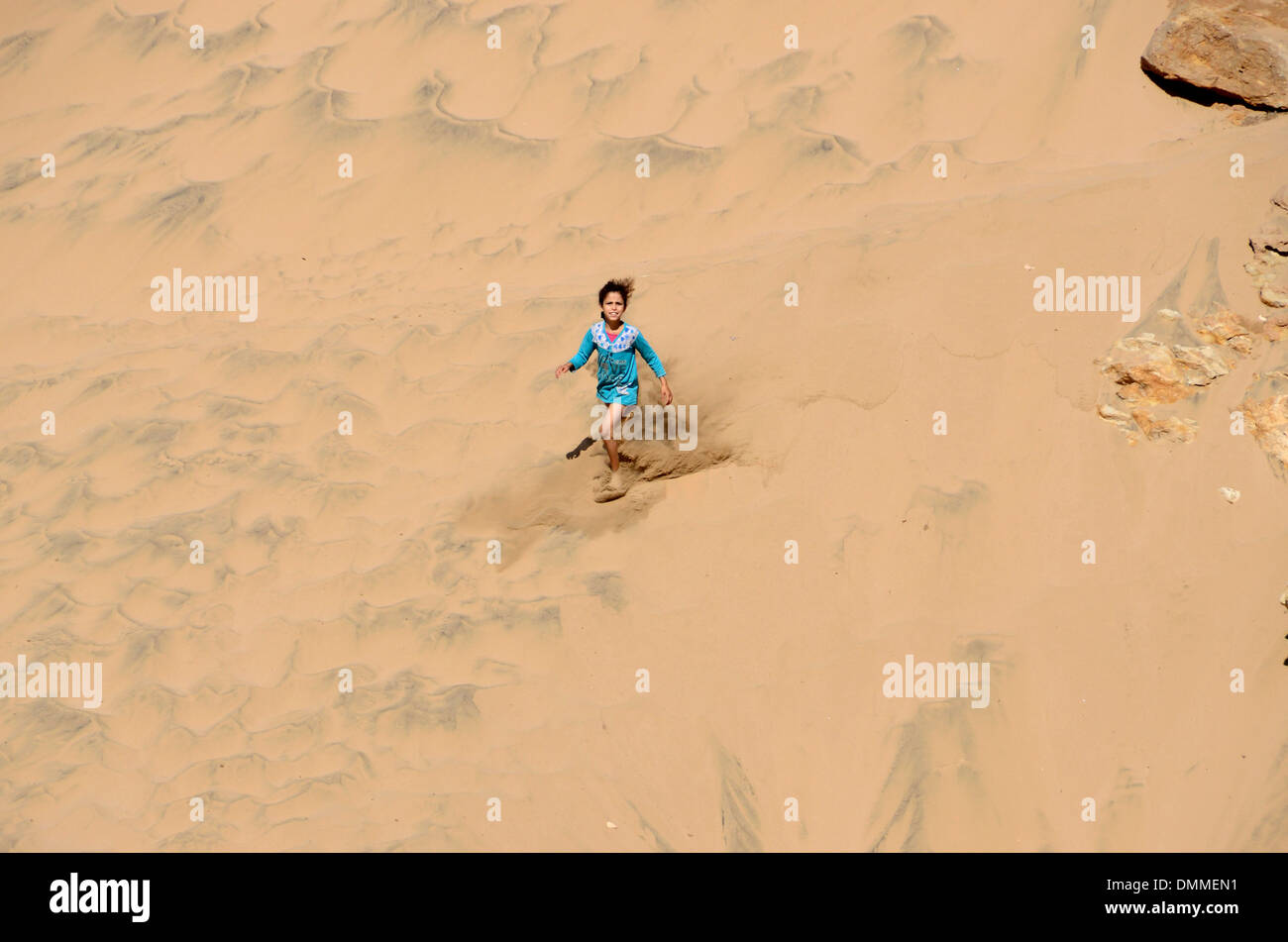 Berber children playing on sand dunes at an oasis near their village ...