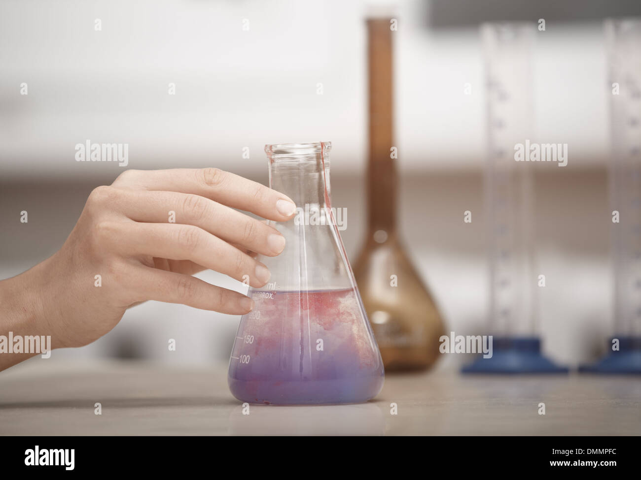 Hand of laboratory technician holding flask with chemical Stock Photo ...
