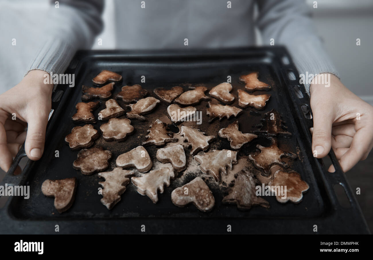 Woman holding baking tray with burnt cookies Stock Photo - Alamy