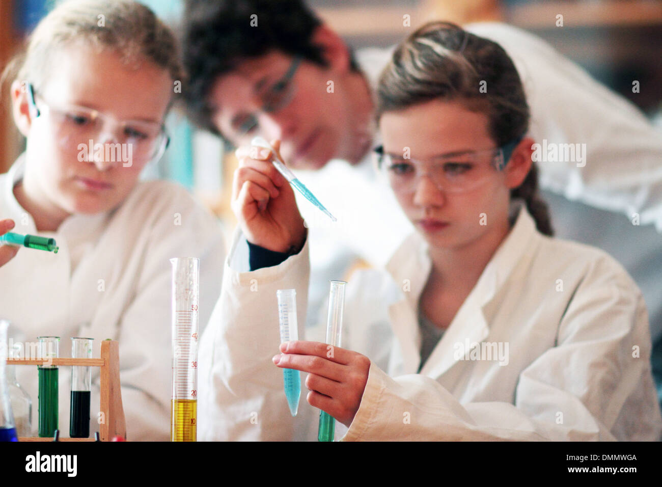 pupils girls learning science chemistry and the teacher looks Stock ...
