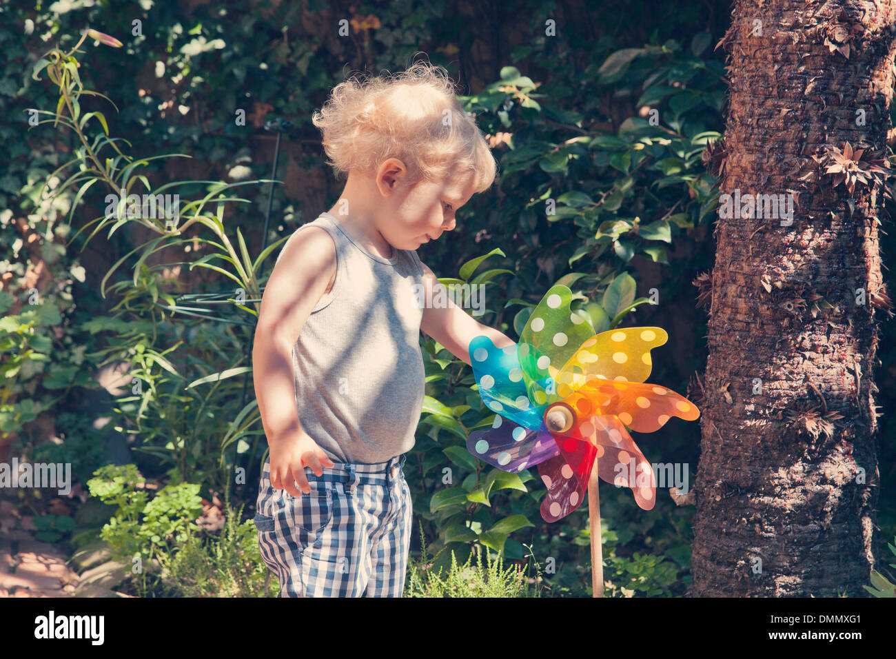 Germany, Bonn, Little boy spinning a colorful wheel in garden Stock ...