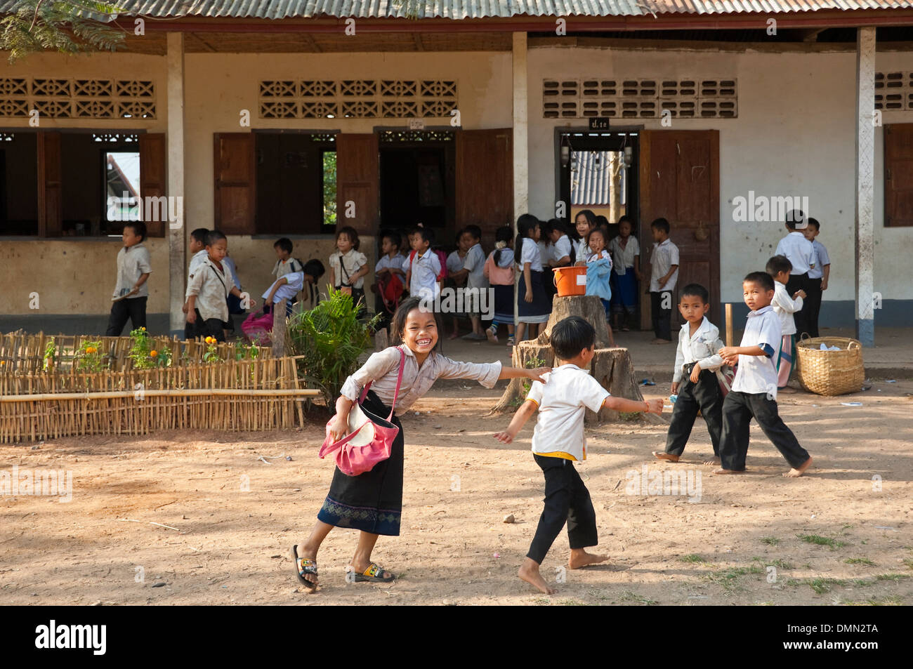 Horizontal portrait of school children playing tag together at a school ...