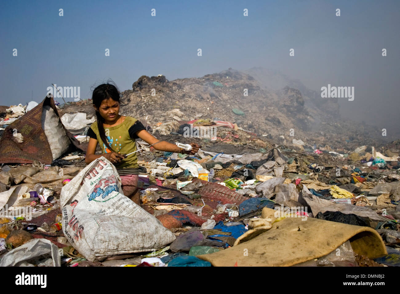 A young child laborer girl is collecting recyclable material at the ...