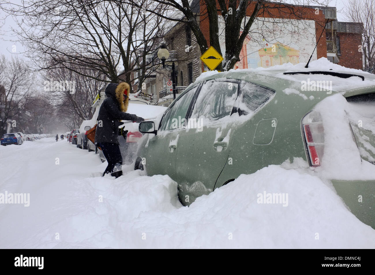 A Woman Clears Off Her Car During A Snowstorm That Left Her Hybrid