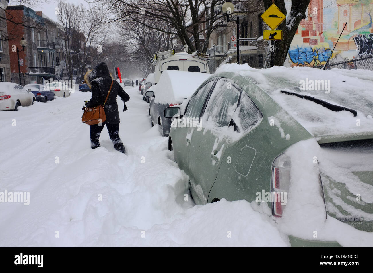 A woman clears off her car during a snowstorm that left her hybrid ...