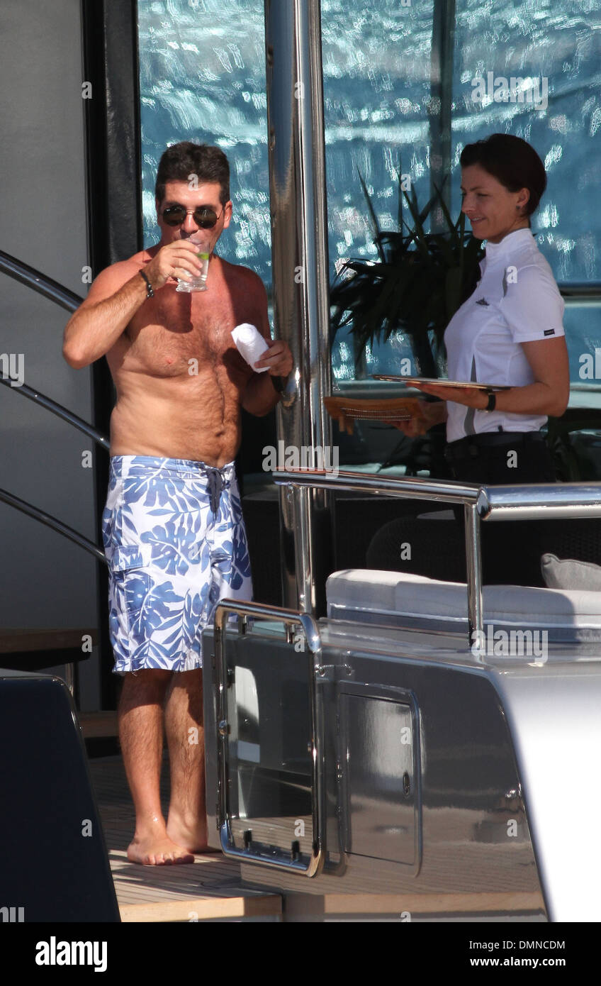 Simon Cowell sips on a drink onboard a luxury yacht during a holiday in ...