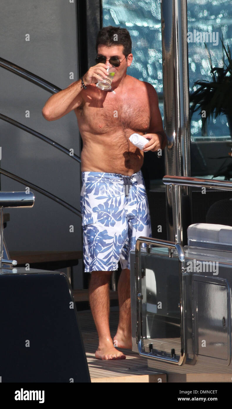 Simon Cowell sips on a drink onboard a luxury yacht during a holiday in ...
