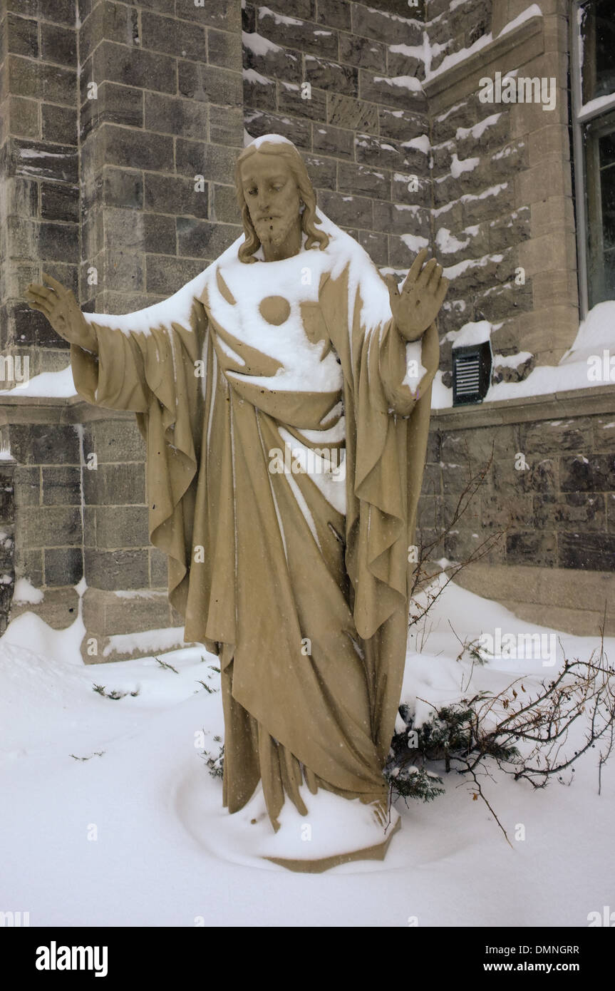 A statue of Jesus Christ covered in snow in the Plateau of Montreal, Quebec Stock Photo - Alamy