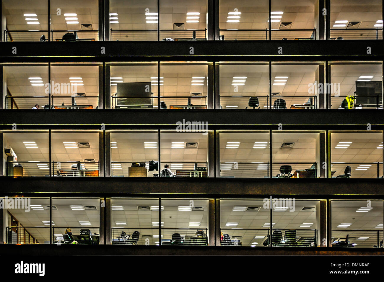 Office block with an all glass frontage showing people at their desks ...