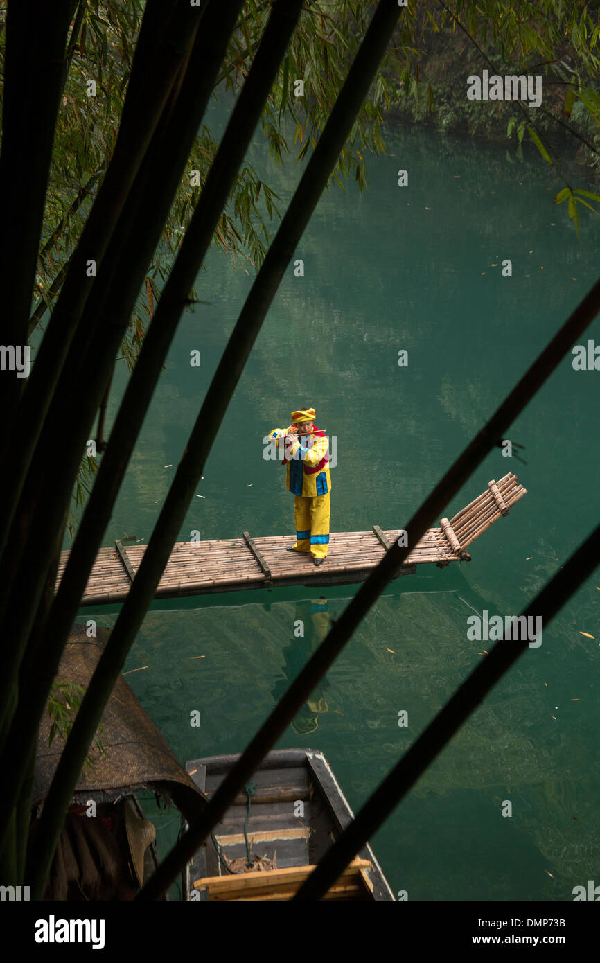 Tribal man playing flute on raft on Daning River China Stock Photo - Alamy