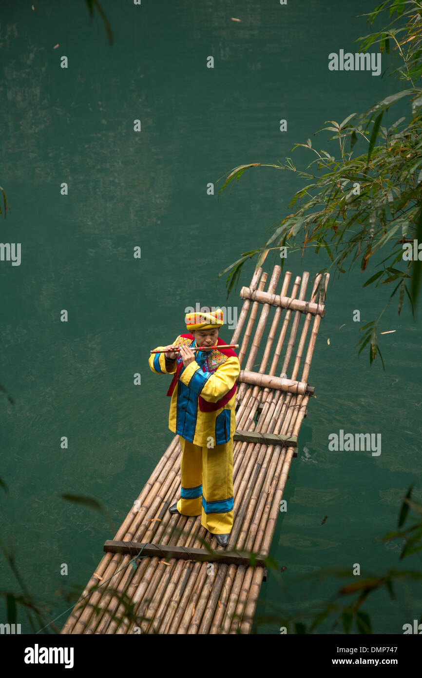 Tribal man playing flute on raft on Daning River China Stock Photo - Alamy