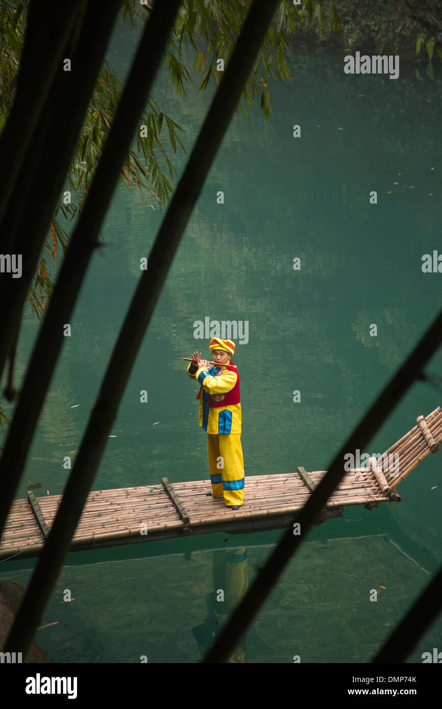 Tribal man playing flute on raft on Daning River China Stock Photo - Alamy