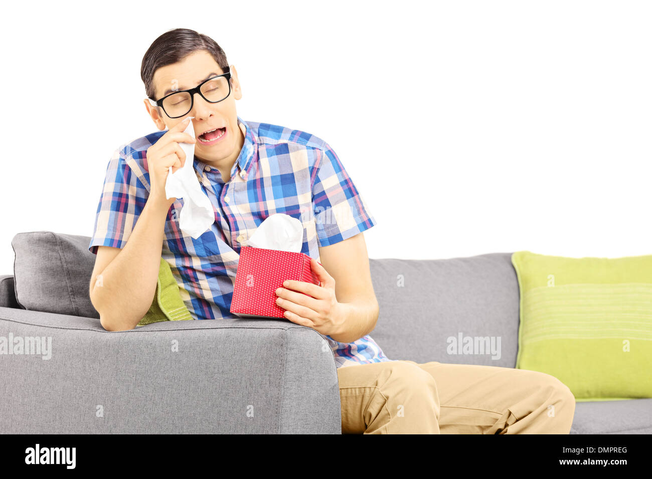 Sad male sitting on a sofa and wiping his eyes from crying Stock Photo ...