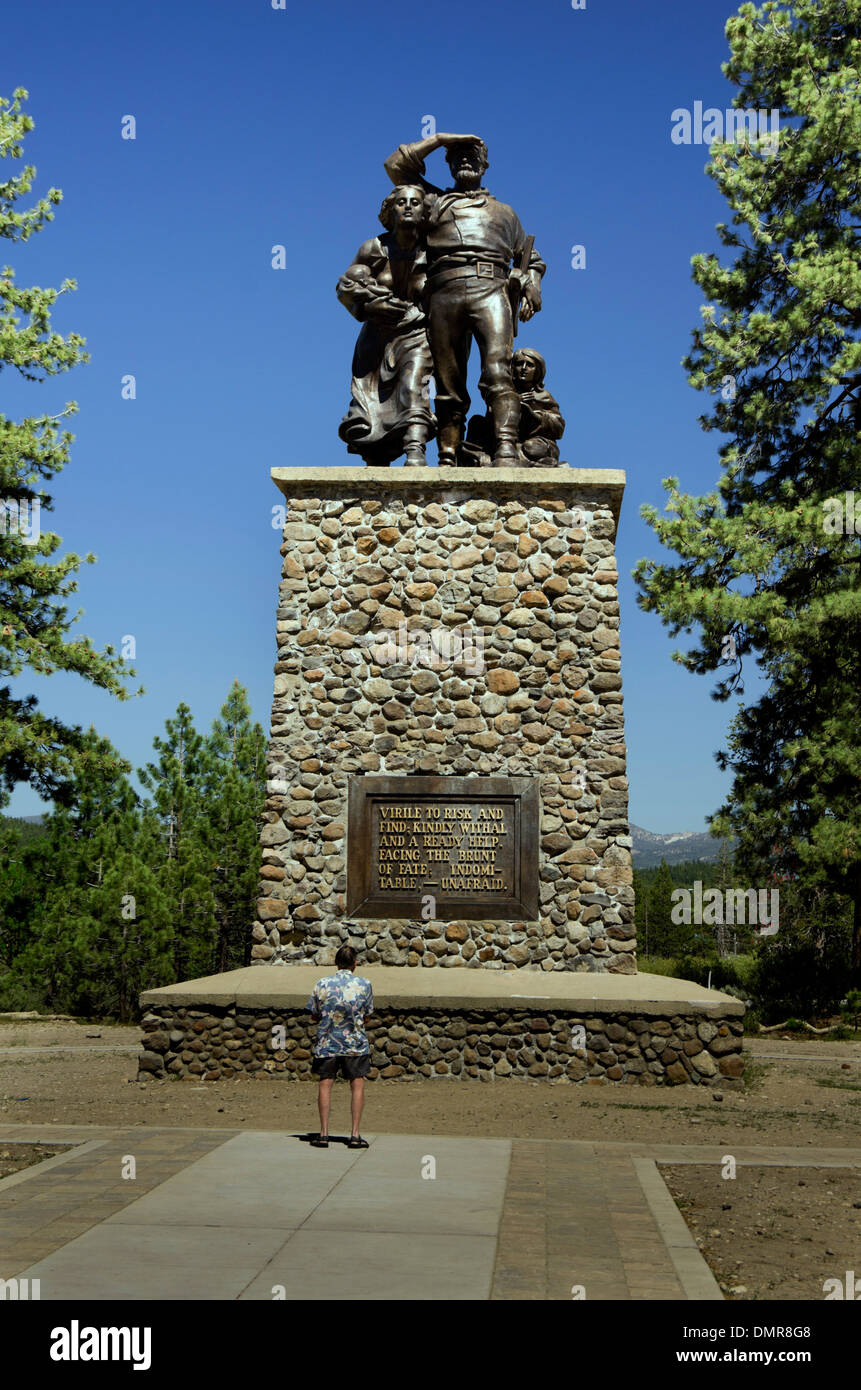 Man stands in front of Donner Pass monument, Statue of father, mother ...