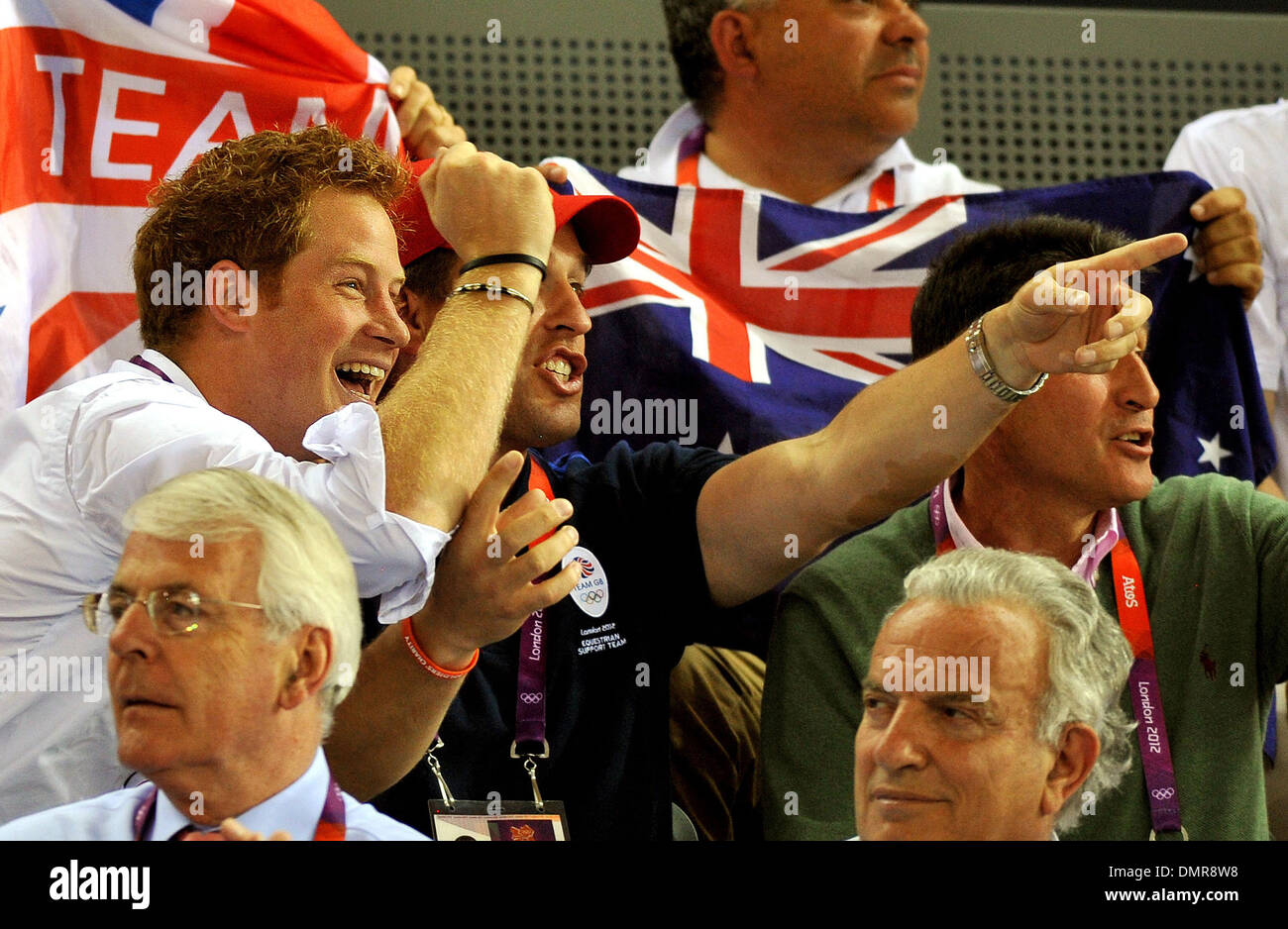 Prince Harry with cousin Peter Phillips and Lord Seb Coe (right) cheer ...