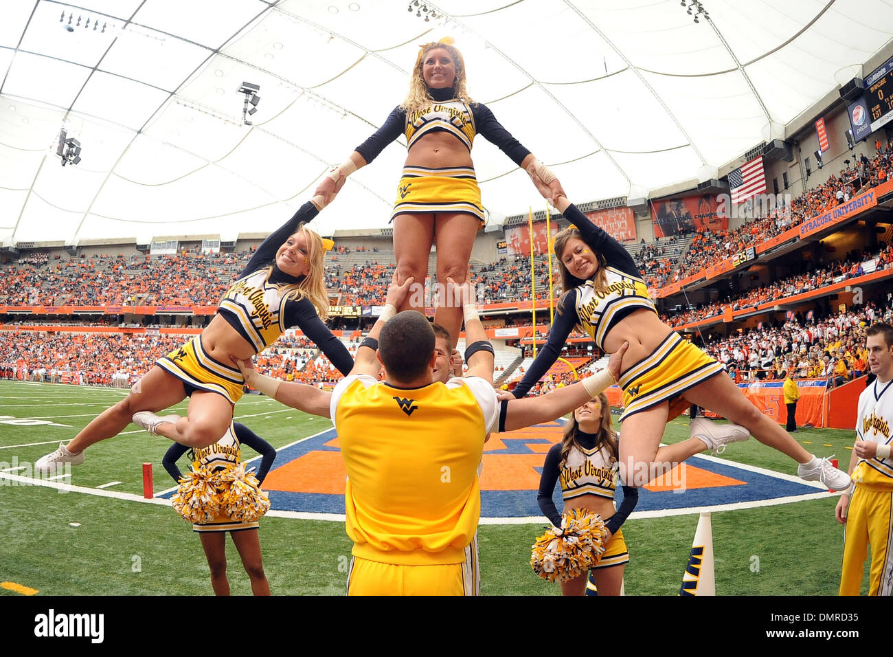 Members of the West Virginia cheerleading squad perform a mount from ...