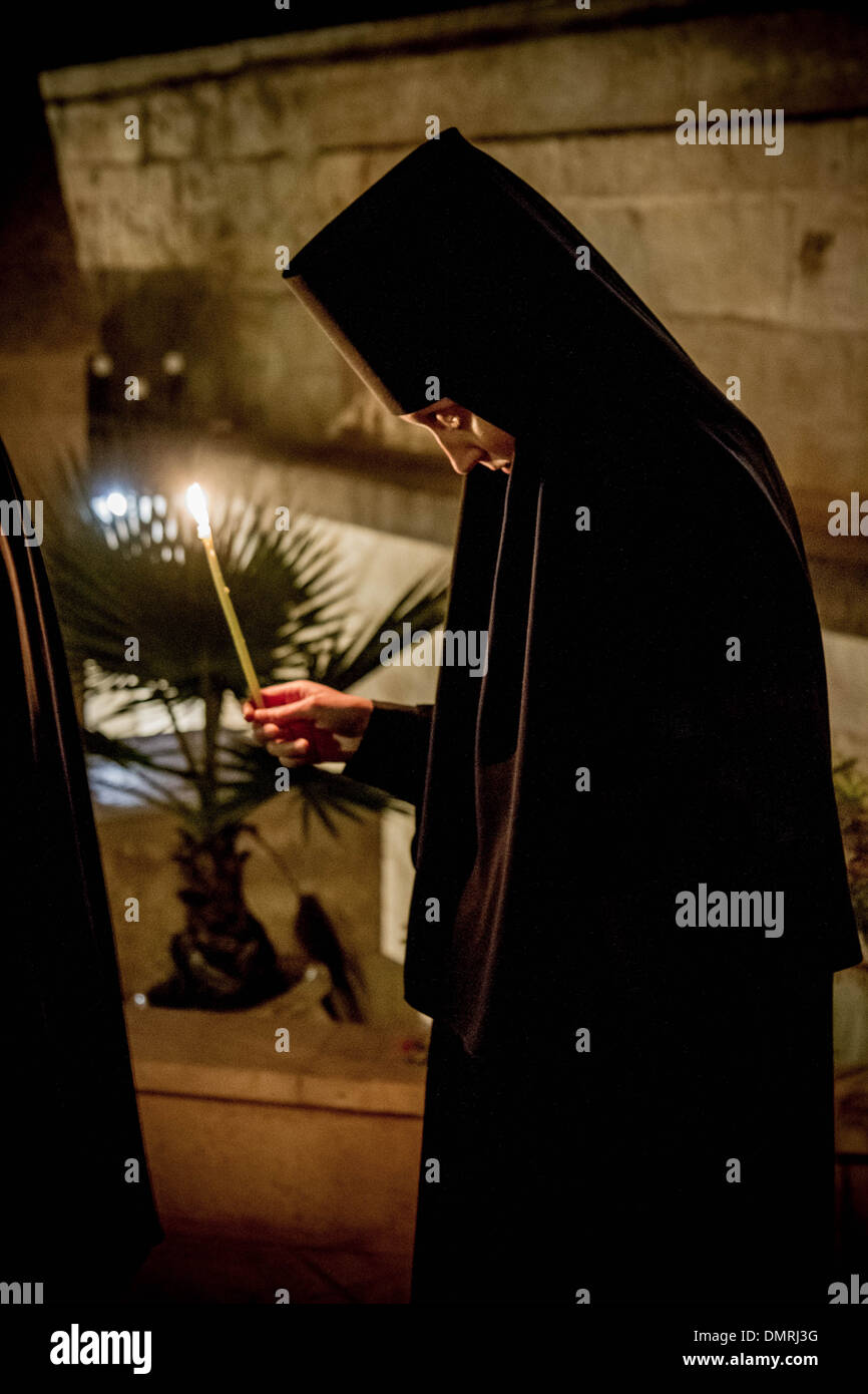 Orthodox nun with prayer candle attending a night liturgy at Gornensky ...