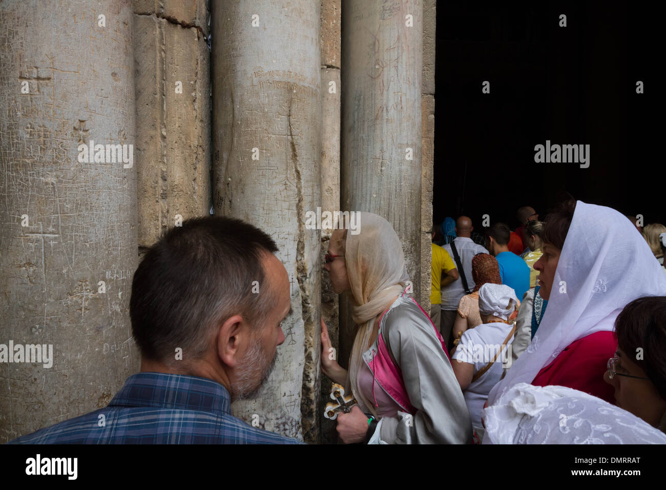 Christian pilgrims pray at the stone pillars by the entrance to The ...
