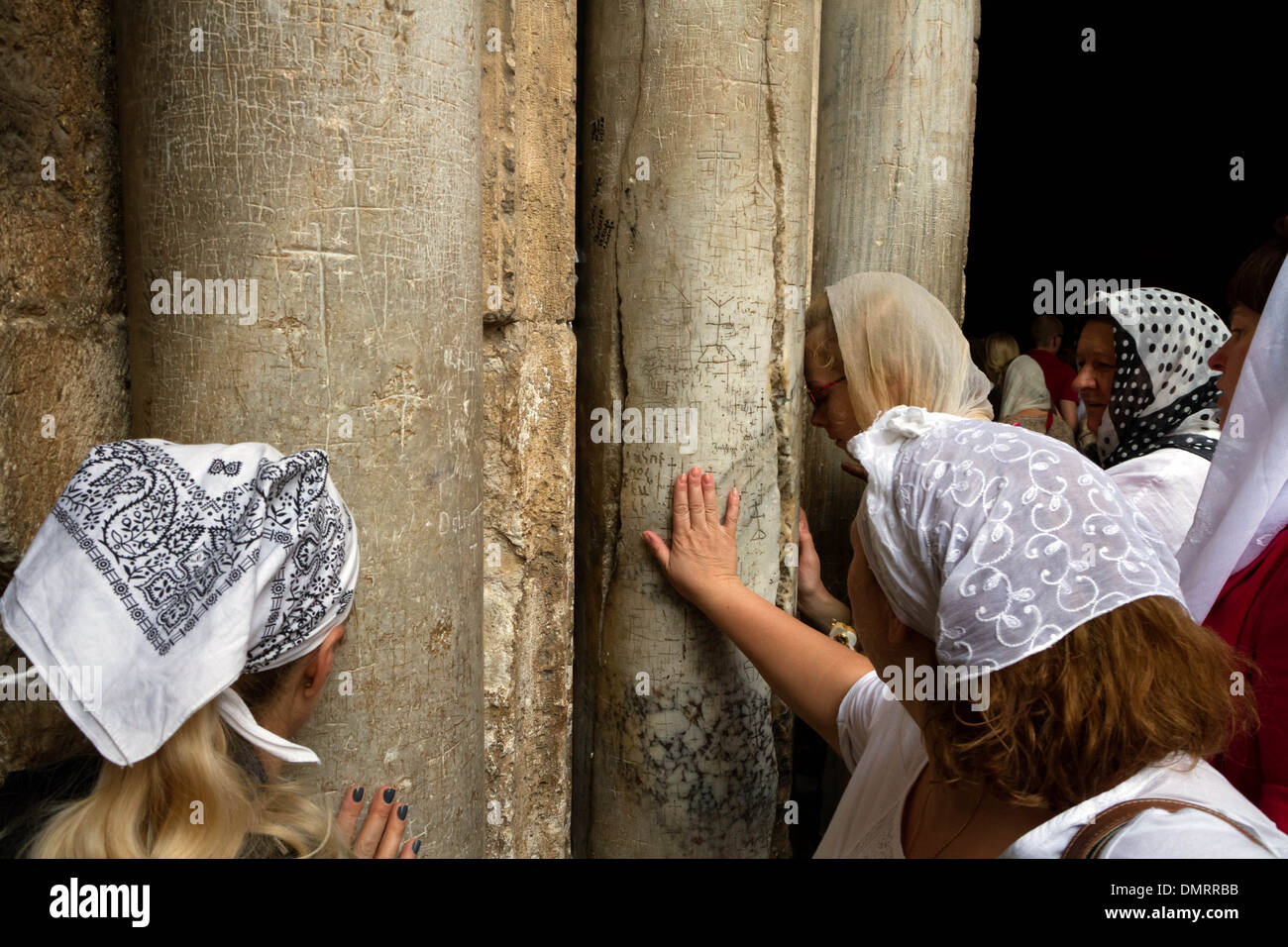 Christian pilgrims pray at the stone pillars by the entrance to The ...
