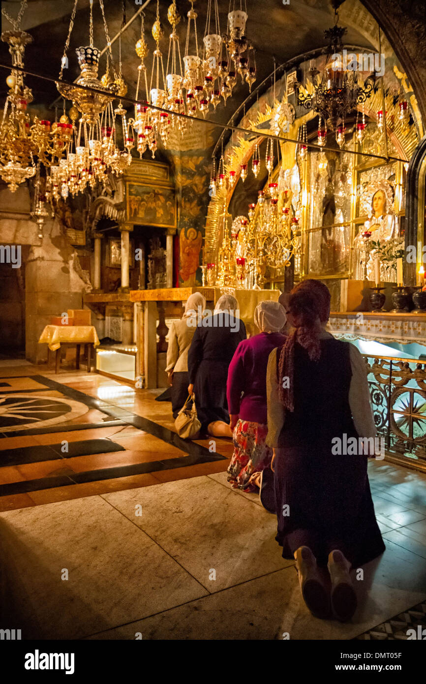 Christian pilgrims queue on their knees preparing to touch the rock of ...