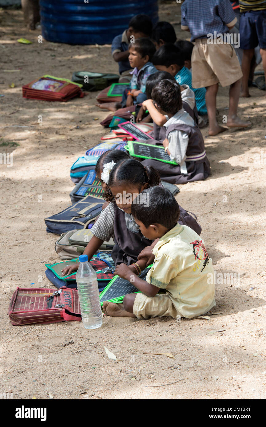 Rural Indian village school children in an outside class writing on a ...