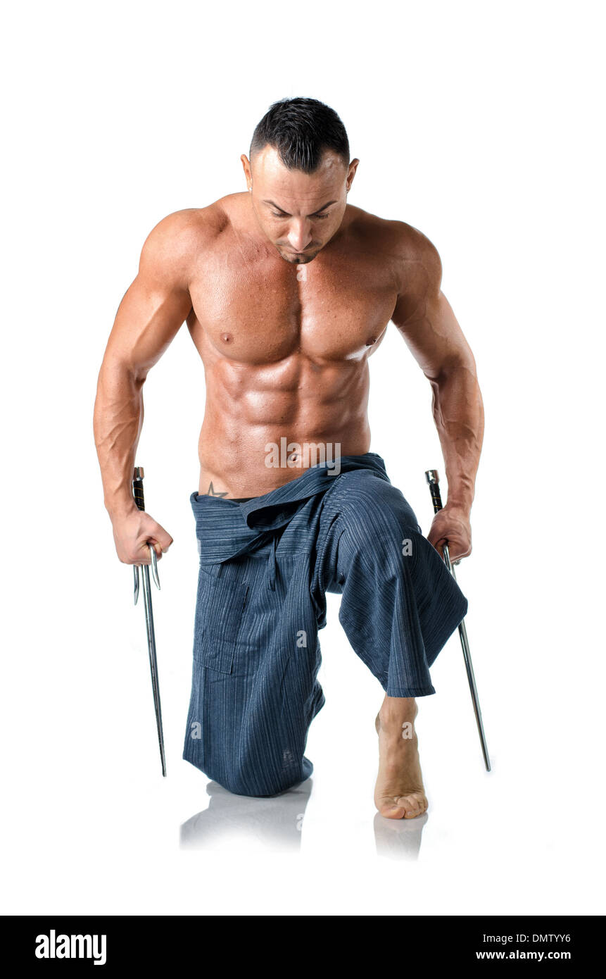 Muscular shirtless man with traditional martial arts daggers, isolated ...