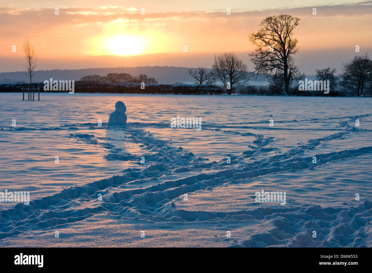 Snowman in snowy field at sunrise Stock Photo - Alamy