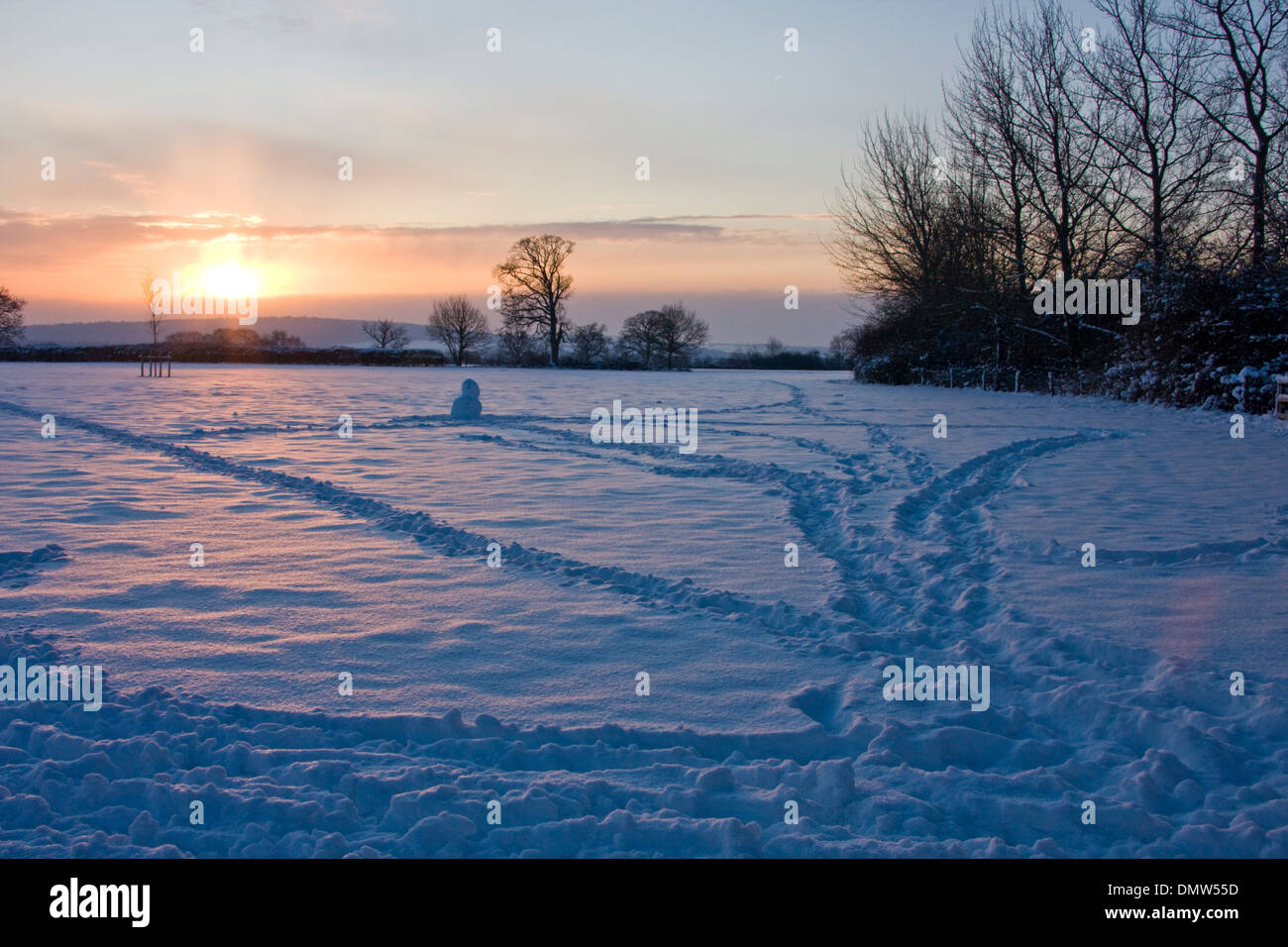 Snowman in snowy field at sunrise Stock Photo - Alamy