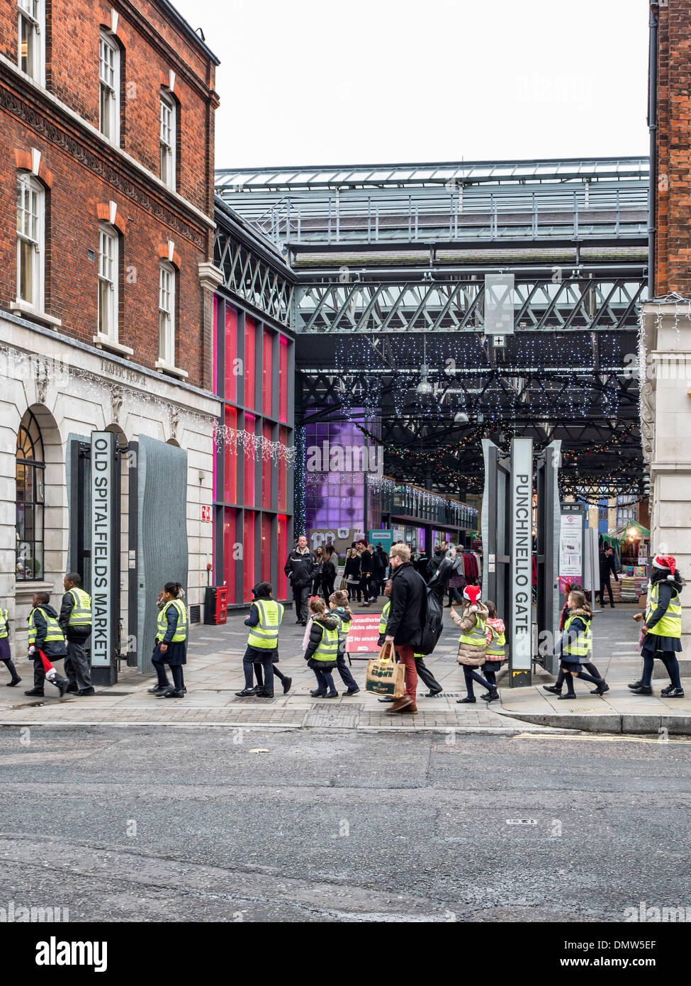 Schoolchildren in yellow safety jackets and red Xmas hats walk past the ...