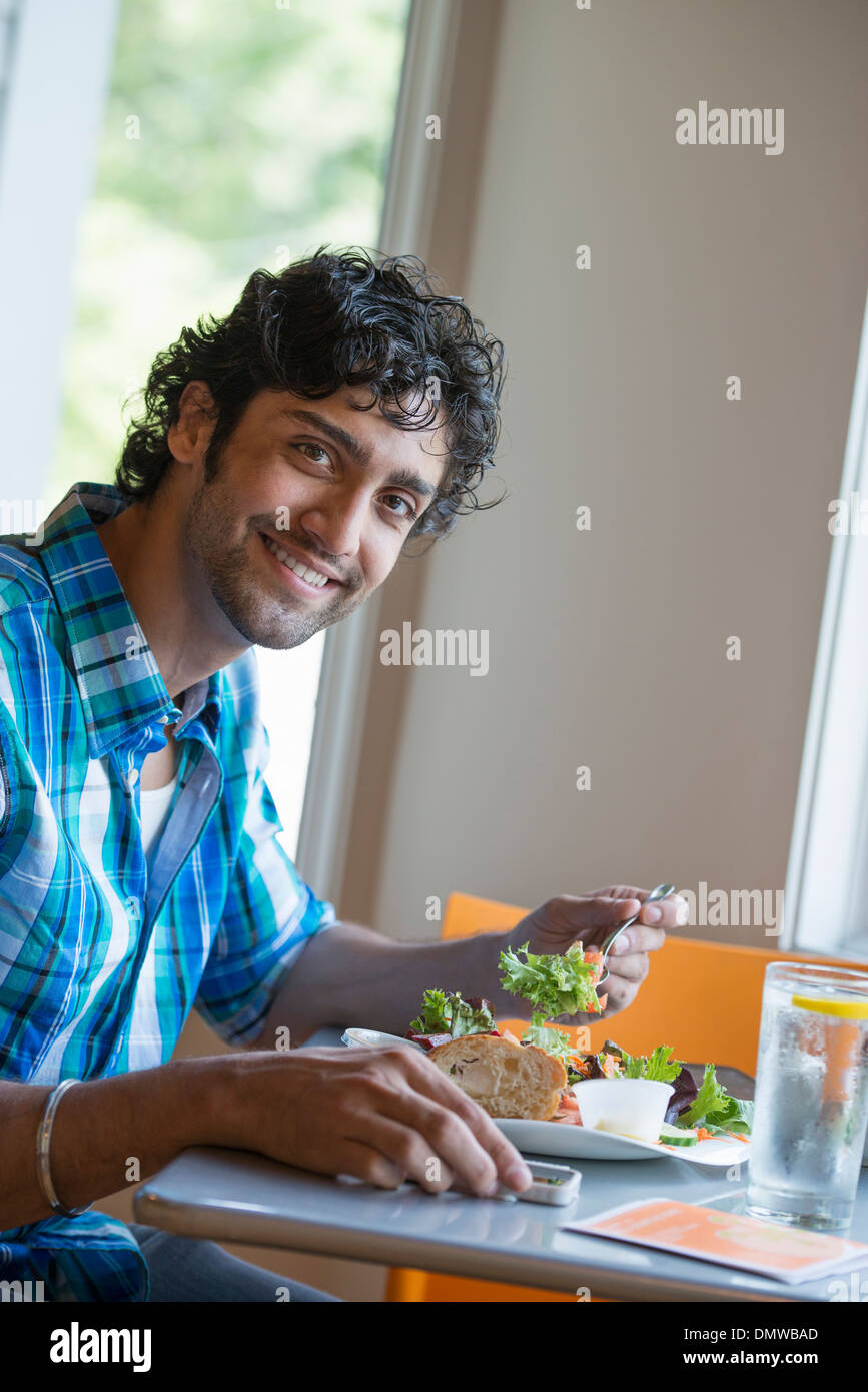 A man checking his phone at a cafe table Stock Photo - Alamy