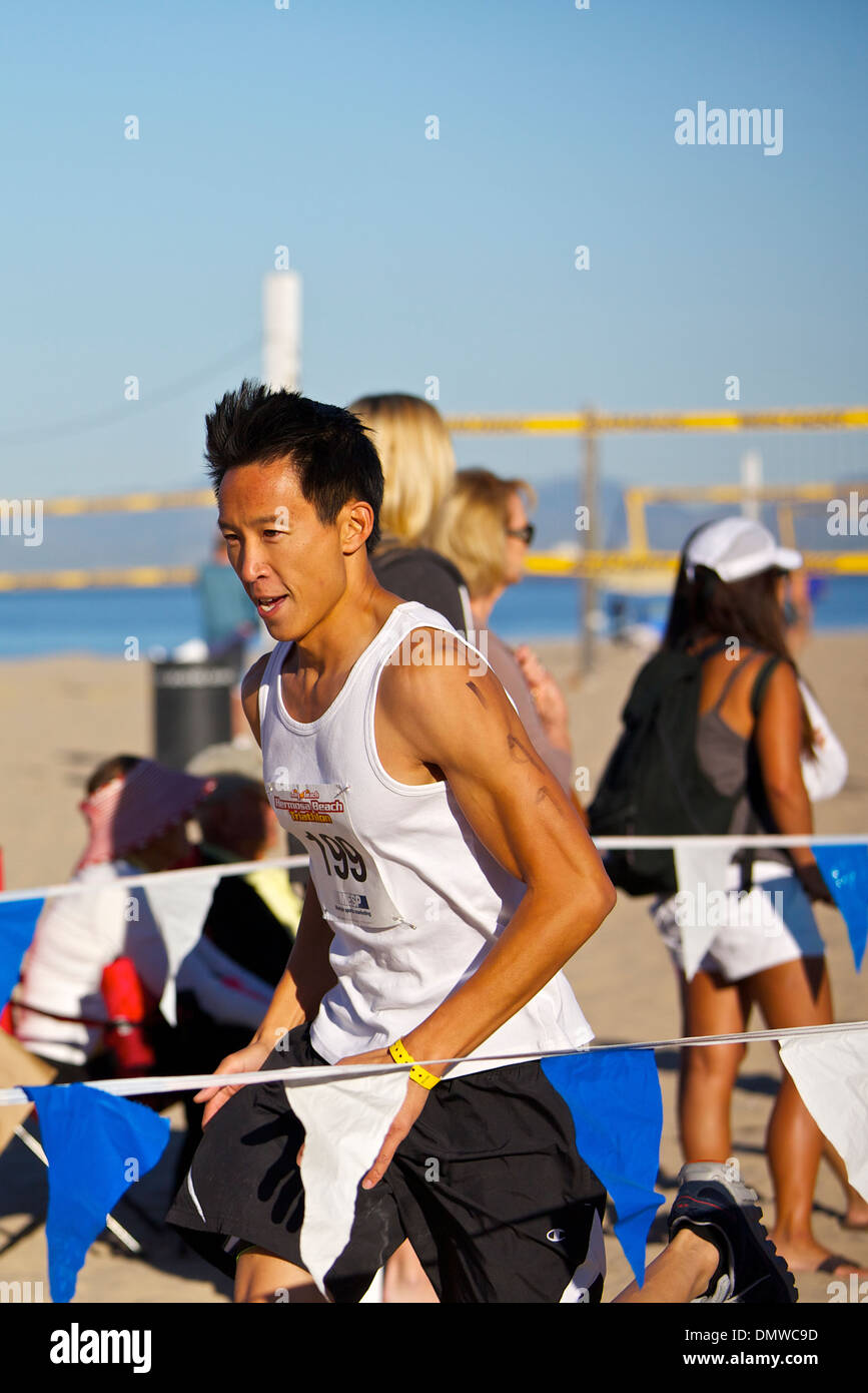Determined Male Chinese American Athlete Approaching The Finish Line At ...