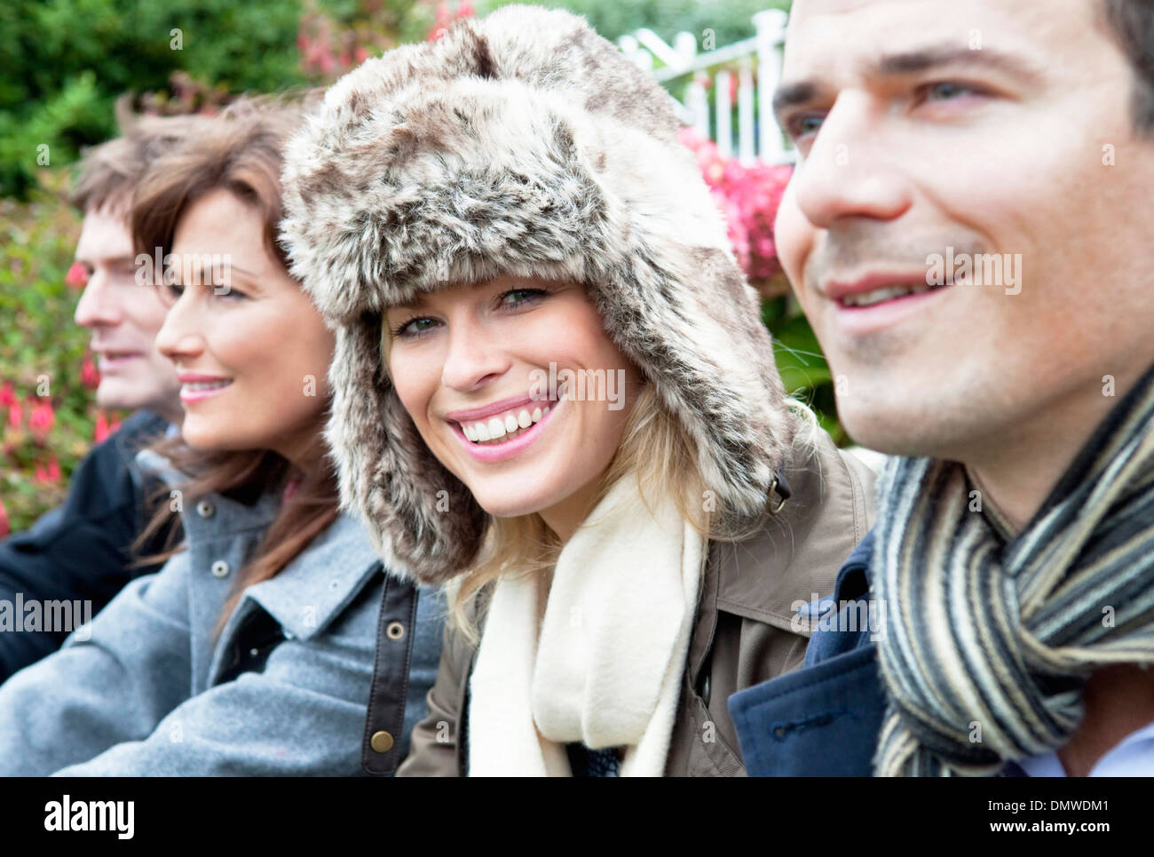 Four people outdoors in coats and scarves Stock Photo - Alamy