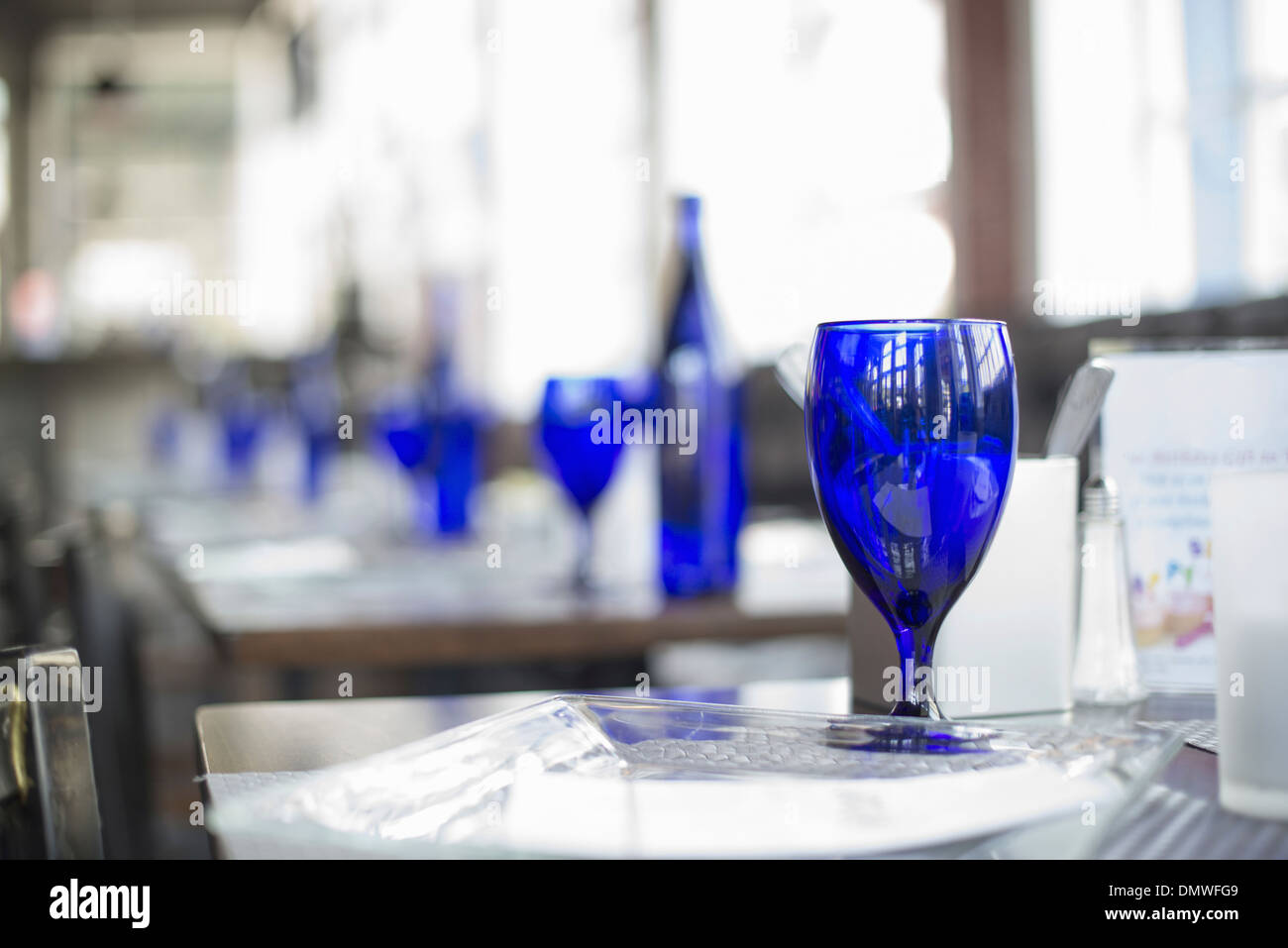A cafe interior. Bright blue glassware on empty tables Stock Photo - Alamy