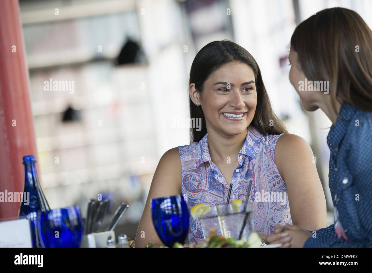 Two women seated at a cafe table having a meal Stock Photo - Alamy
