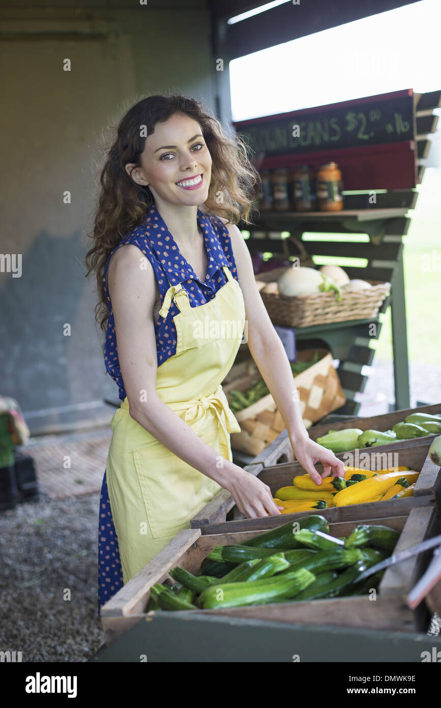 An organic fruit and vegetable farm. A young woman sorting vegetables ...