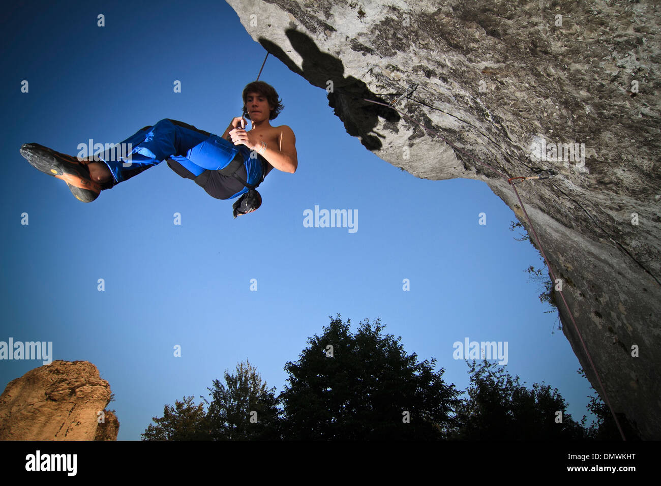 Rock climber rapelling down from a limestone cliff. Mirow, Jura ...