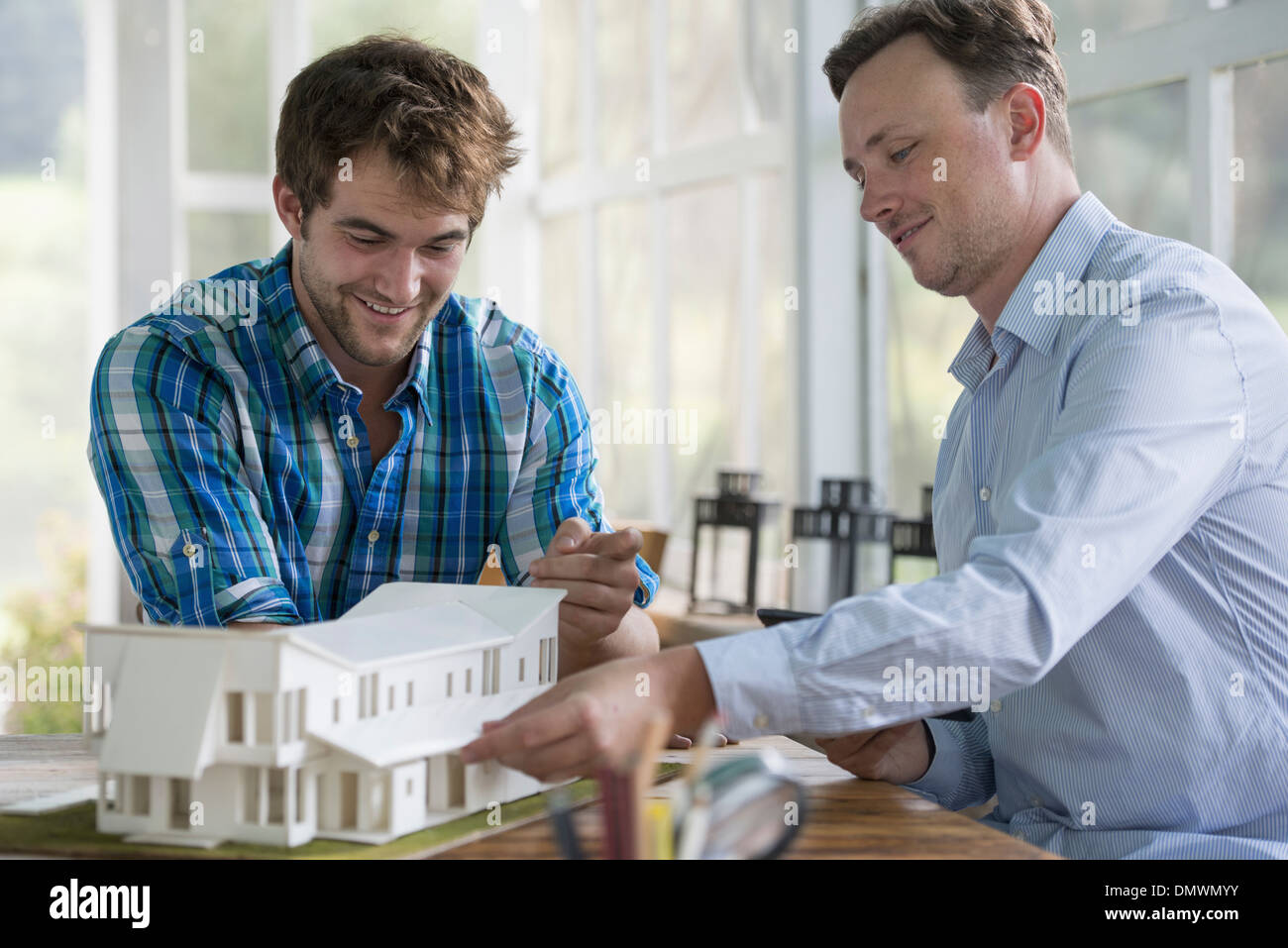 Two men looking at an architectural model of a house Stock Photo - Alamy