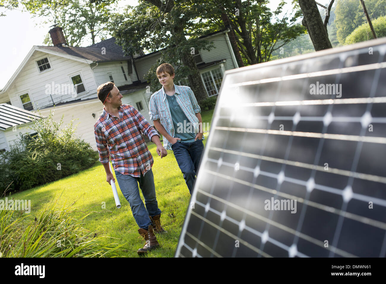 Two people walking towards a farmhouse garden Stock Photo - Alamy