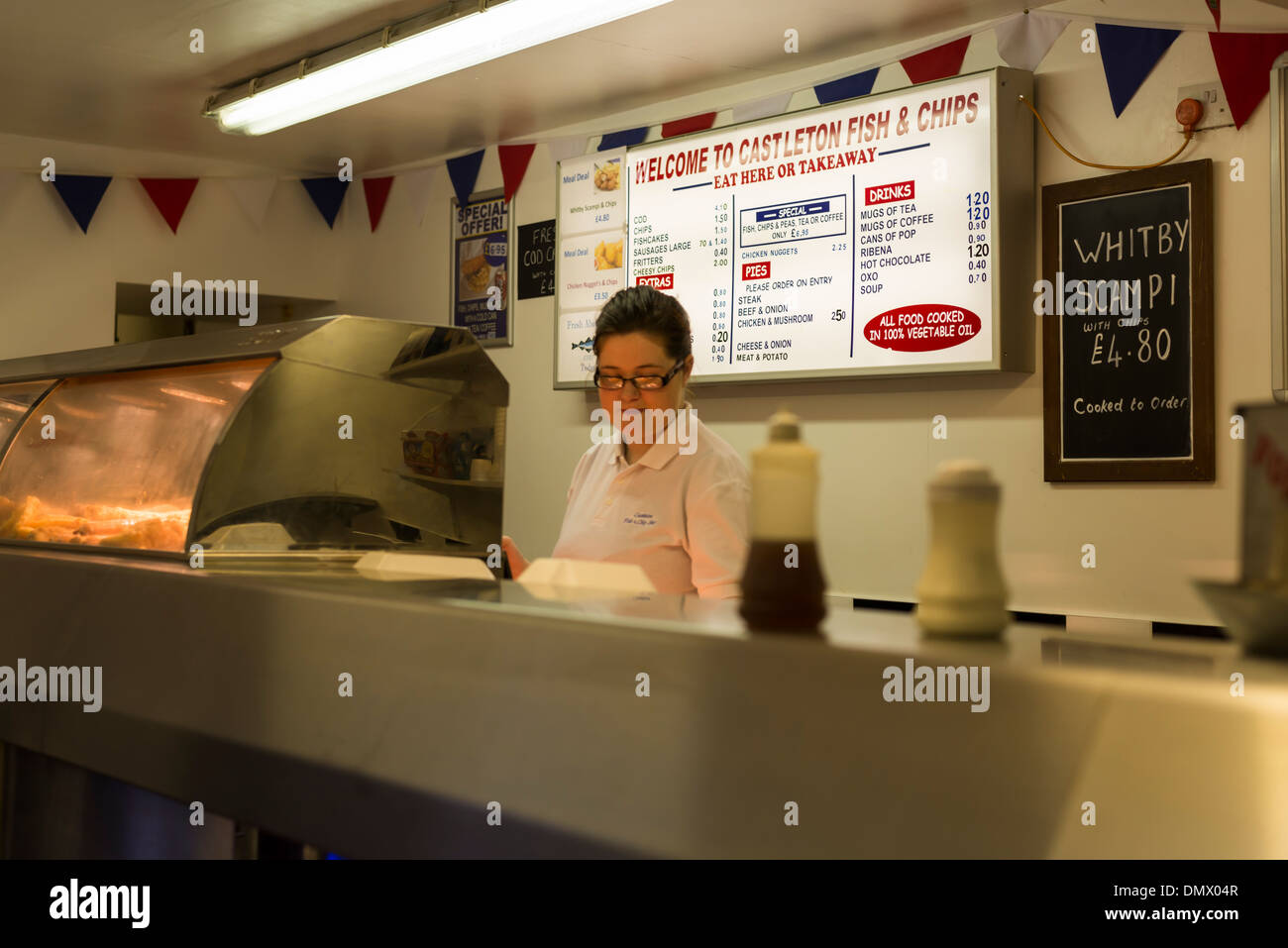 Girl/woman standing behind Fish and chip shop counter in Castleton ...