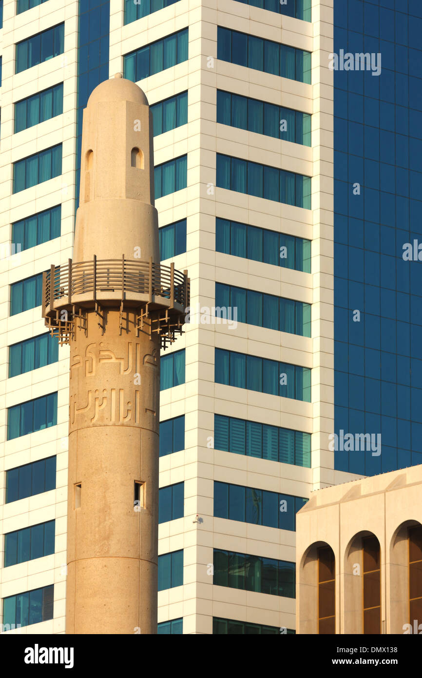 Minaret of the Beit al-Quran seen against the facade of a modern office ...